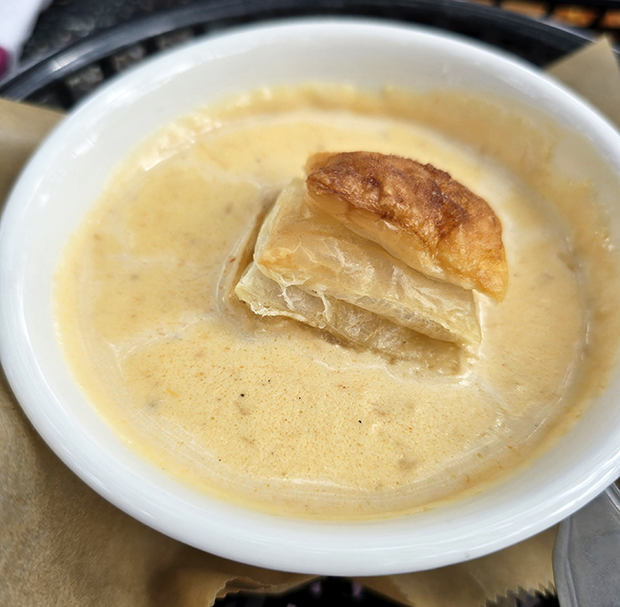 The legendary She-Crab Soup arrives like a warm hug in a bowl, crowned with puff pastry that's practically begging for a slow-motion video.