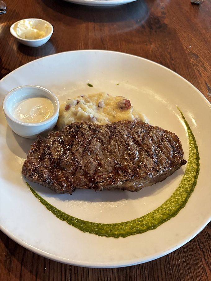 This isn't just a steak; it's a masterclass in simplicity. Perfect grill marks, a green sauce swipe, and potatoes that didn't know they could be this good.