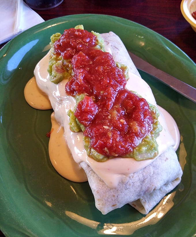 Behold the burrito in its final form&mdash;smothered in queso, crowned with salsa, and cradled by guacamole. This isn't fast food; it's slow happiness.