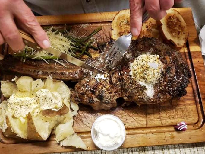 This isn't just a steak, it's a declaration of love on a wooden board. The pat of butter melting on top is nature's perfect sauce.