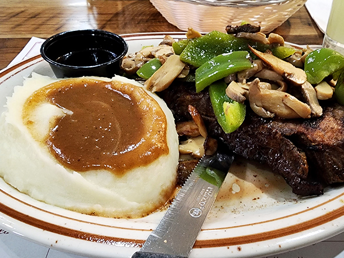 Mashed potatoes swimming in gravy alongside perfectly seared steak and fresh vegetables. This plate doesn't need Instagram filters&mdash;it's the real deal.