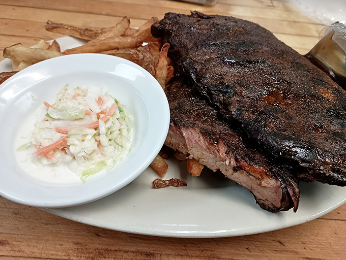 Behold, the star of the show! A perfectly seared steak with a beautiful pink center, accompanied by hand-cut fries and creamy coleslaw.