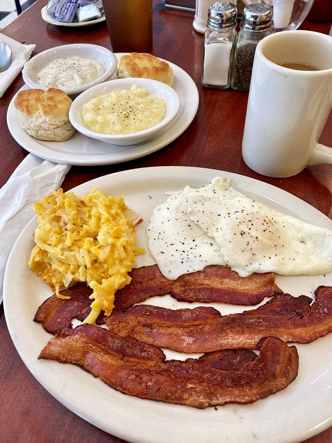 Breakfast nirvana achieved: perfectly cooked eggs, bacon with that ideal crisp-to-chewy ratio, and biscuits that would make your grandmother jealous.
