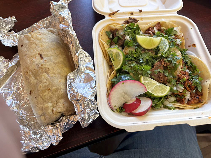 The perfect partnership: a foil-wrapped burrito alongside street-style tacos garnished with fresh cilantro, onions, and lime wedges. Name a more iconic duo.