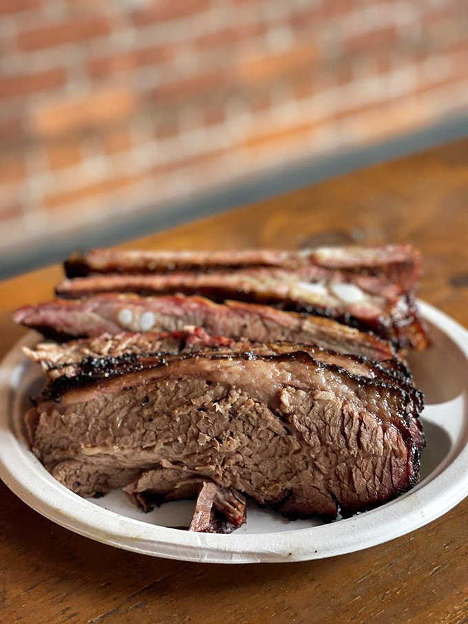 Behold the brisket—that perfect pink smoke ring is the barbecue equivalent of a Michelin star. Worth every minute in line.