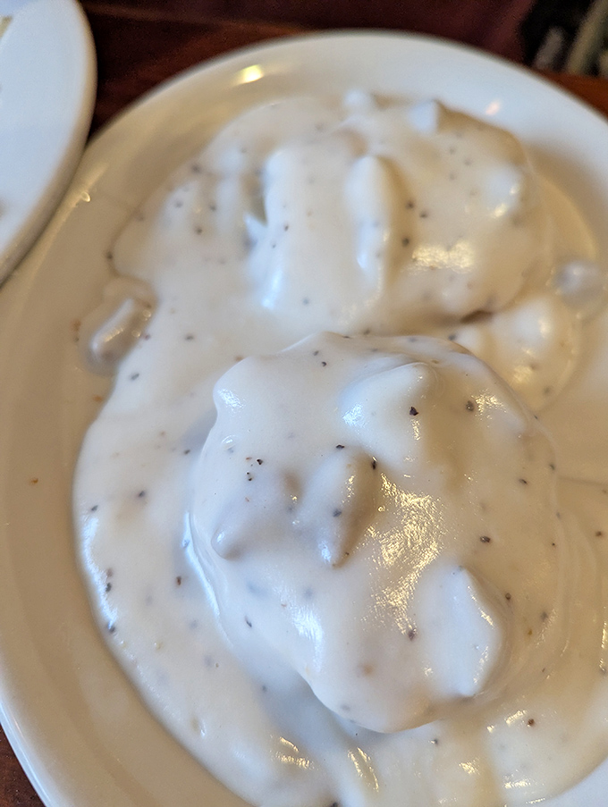 This isn't just country gravy; it's a creamy, peppery blanket of comfort that transforms ordinary biscuits into the breakfast equivalent of winning the lottery.