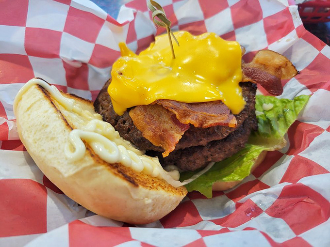 Behold the cheeseburger in its natural habitat—draped in melted American cheese with bacon standing at attention, all nestled in a bun that's toasted just right.