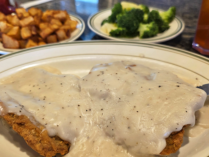 This isn't just country fried steak &ndash; it's a golden-breaded masterpiece swimming in peppery gravy that would make any Southern grandmother nod in approval.