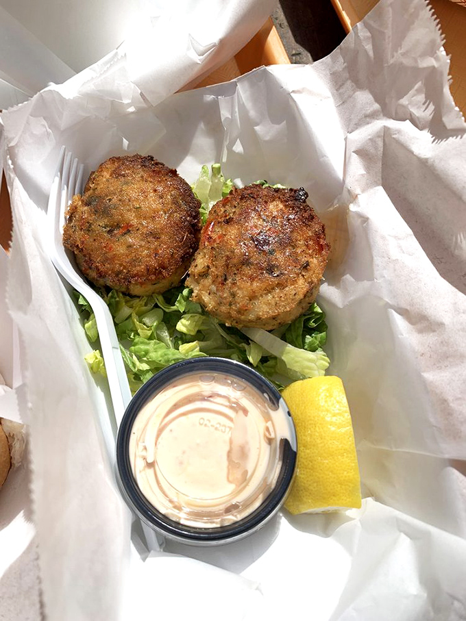Golden-brown crab cakes that could make a New Englander weep with joy. Crispy exterior, tender inside, and that sauce? Perfection.