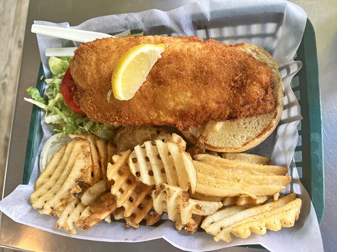 This isn't just a fish sandwich; it's a golden-battered masterpiece on a throne of waffle fries that demands to be photographed before devoured.