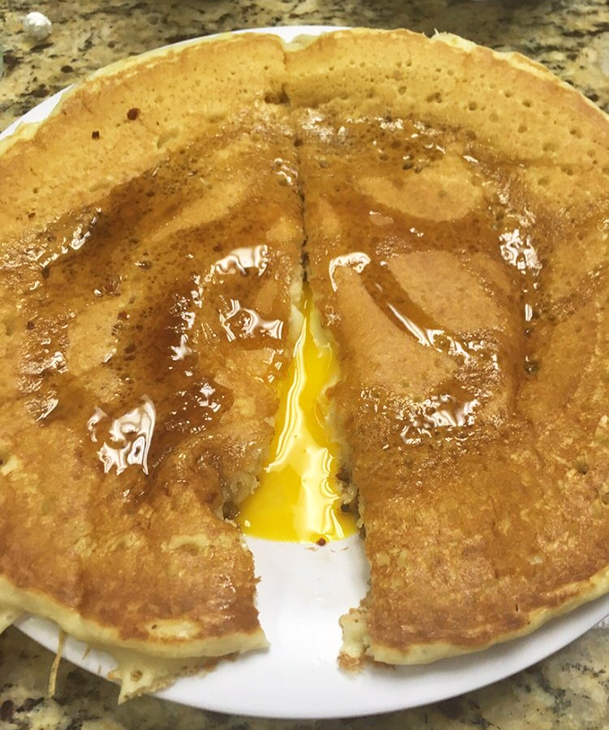 Breakfast nirvana achieved: a golden-brown pancake with that perfect crispy edge and a river of maple syrup. This is what breakfast dreams are made of. 