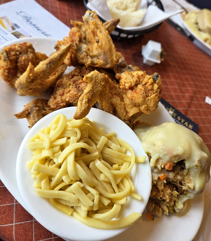 Golden-brown fried chicken that shatters with each bite, paired with buttery egg noodles—comfort food that speaks a universal language.
