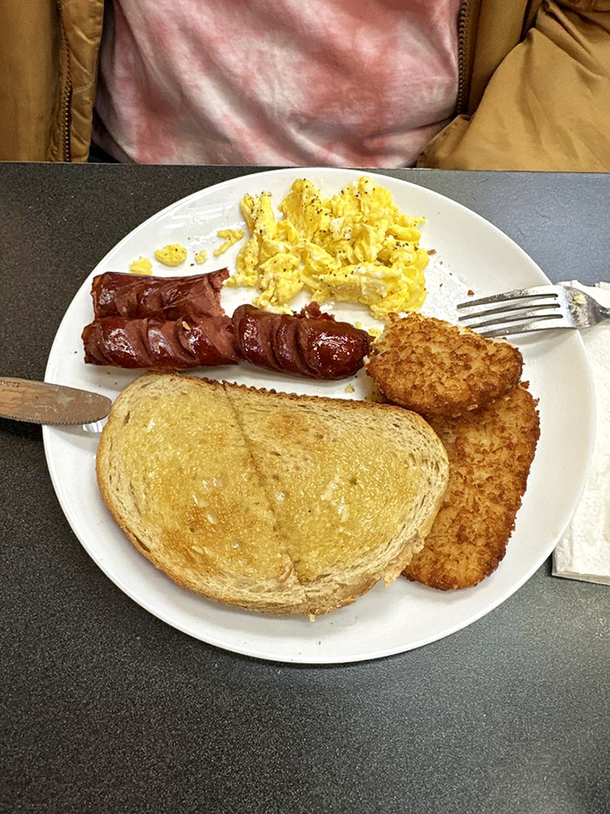 Breakfast classics executed with precision: golden toast, perfectly scrambled eggs, and sausage links that snap with satisfaction at first bite.