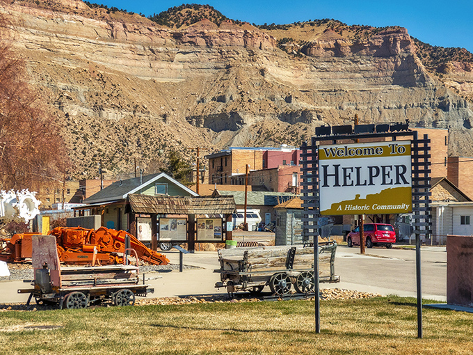 The "Welcome to Helper" sign stands guard like a friendly sentinel, surrounded by mining equipment that tells the story of this town's industrious past.