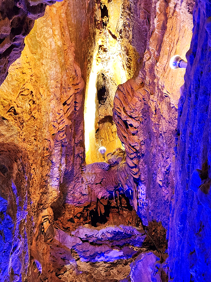 Technicolor lighting transforms ordinary limestone into an otherworldly landscape that feels like walking through a sci-fi movie set.