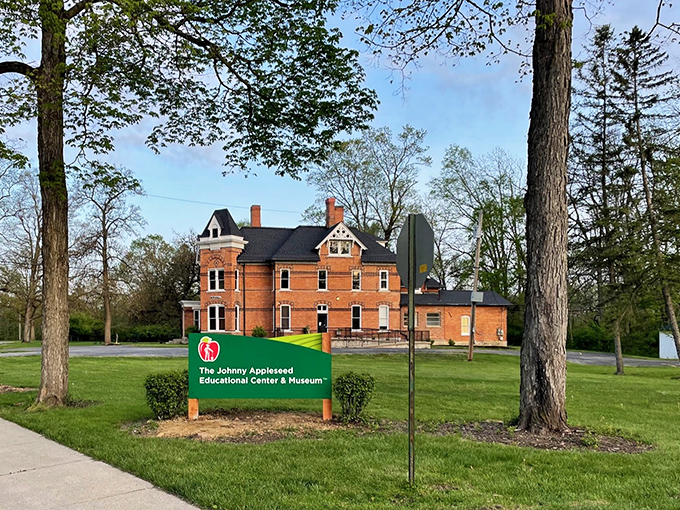 The Johnny Appleseed Educational Center stands proudly among towering trees, a brick testament to America's favorite wandering orchardist and his legendary seeds.