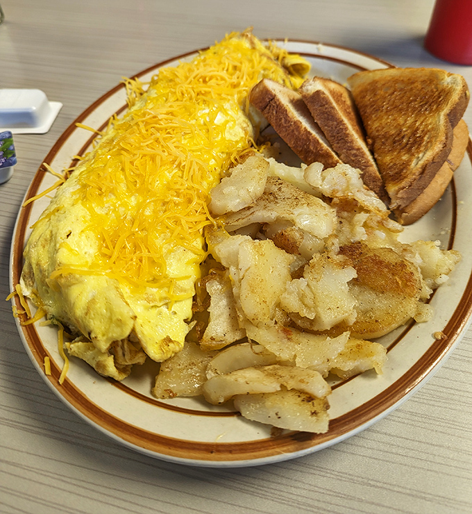 Behold the cheese omelet in its natural habitat&mdash;flanked by golden home fries and perfectly toasted bread. A breakfast trinity that never disappoints.