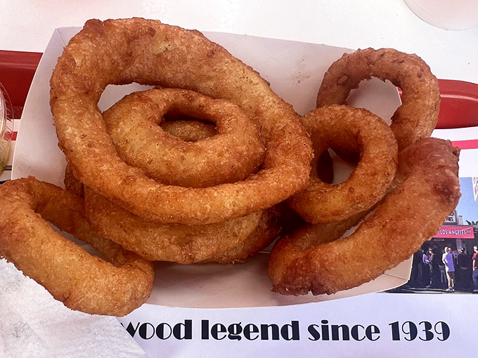 Golden onion rings that achieve the perfect balance between crispy armor and sweet, tender surrender underneath.