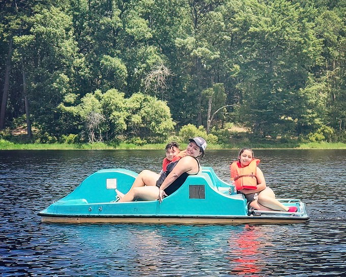Family memories being made one paddle at a time. That smile says "vacation success" even if those life jackets scream "fashion disaster."