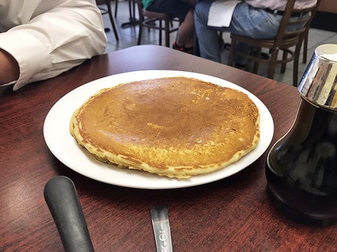 Behold the pancake that launched a thousand breakfast pilgrimages &ndash; golden, plate-sized, and waiting for its maple syrup baptism.