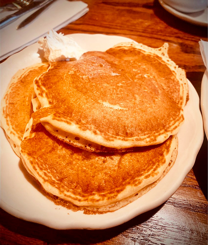 Golden-brown buttermilk pancakes stacked high enough to make you wonder if your mouth can unhinge like a snake's. Worth finding out.