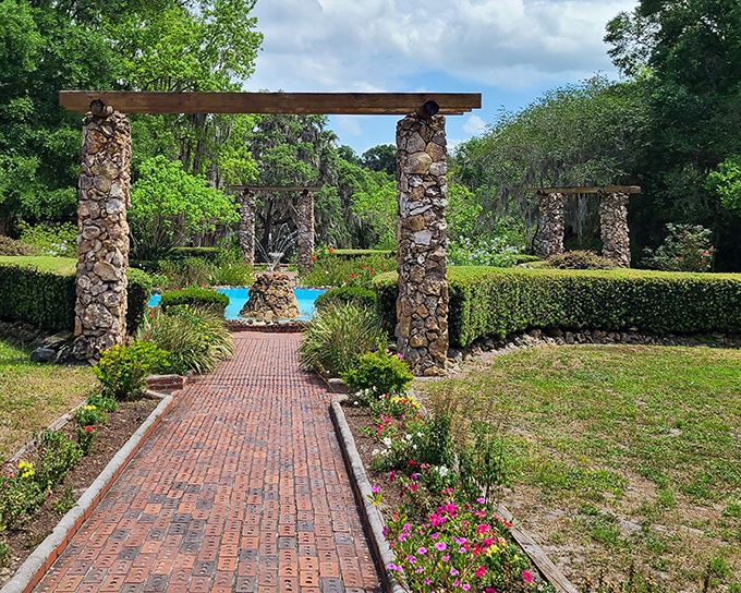 Brick pathways flanked by stone columns create the sense that you're walking through a Roman ruin that's been colonized by Florida's lush greenery.