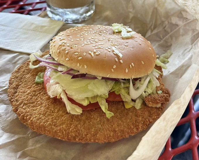 The legendary breaded tenderloin – a golden-brown masterpiece that refuses to be contained by mere bread. Indiana's unofficial state sandwich in its natural habitat.