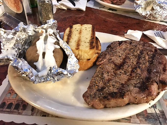 A perfectly grilled steak alongside a foil-wrapped baked potato loaded with the works &ndash; proof that some culinary equations never need solving.