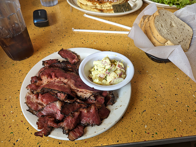 Pastrami so tender it practically surrenders to your fork, accompanied by that legendary potato salad&mdash;a side dish that refuses to be upstaged.