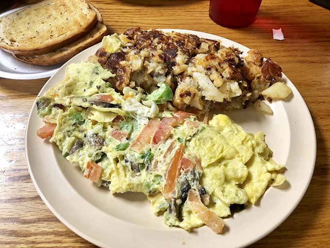 Fluffy eggs cradle fresh vegetables in this colorful omelet masterpiece. Each bite delivers the perfect balance of textures and morning flavors.