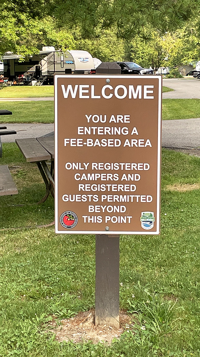 The official greeter of adventure! This sign might mention fees, but the memories you'll make beyond this point? Absolutely priceless.