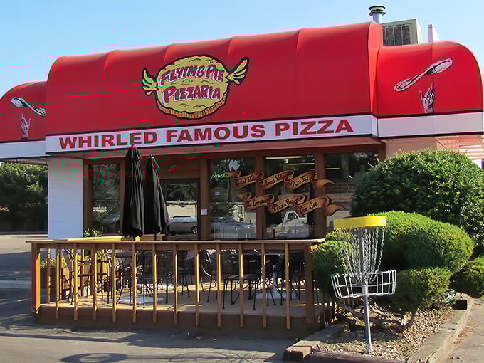 That bold red roof is Flying Pie's way of saying "pizza party here!" The disc golf basket hints at the fun vibe inside.