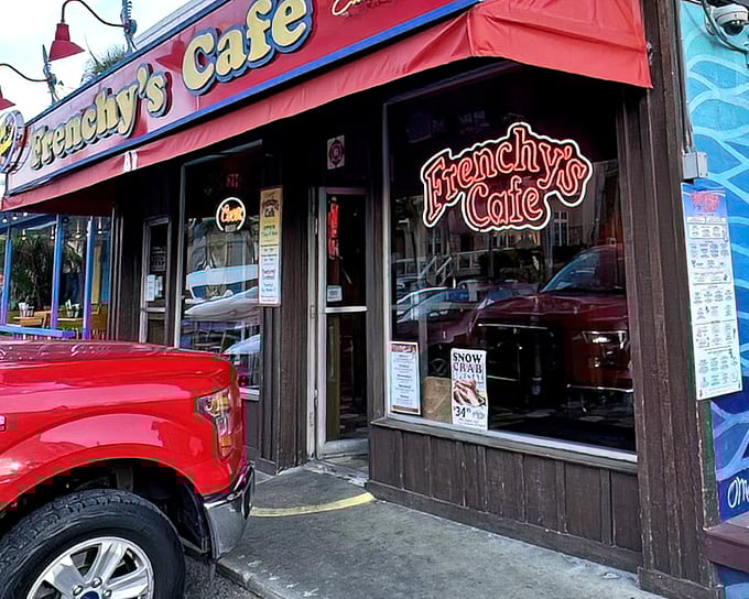 Frenchy's neon sign glows like a lighthouse for hungry travelers seeking the holy grail of grouper sandwiches.