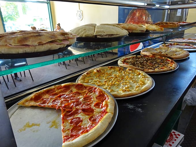 Fresh pizza perfection sits under warming lights, each slice promising that perfect first bite you've been craving all day.