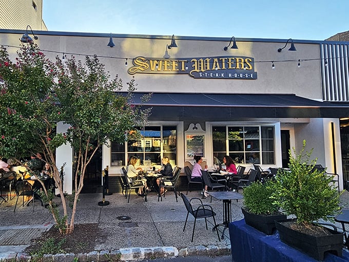 Sweet Waters' inviting patio scene &ndash; where summer evenings, good company, and exceptional steaks create perfect memories.
