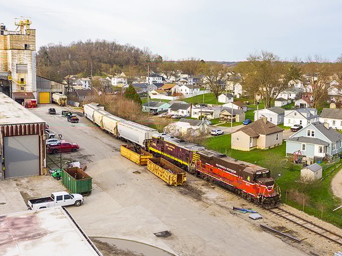 A freight train winds through Zanesville's industrial corridor, the lifeblood of commerce flowing through this historic transportation hub nestled among green hills.
