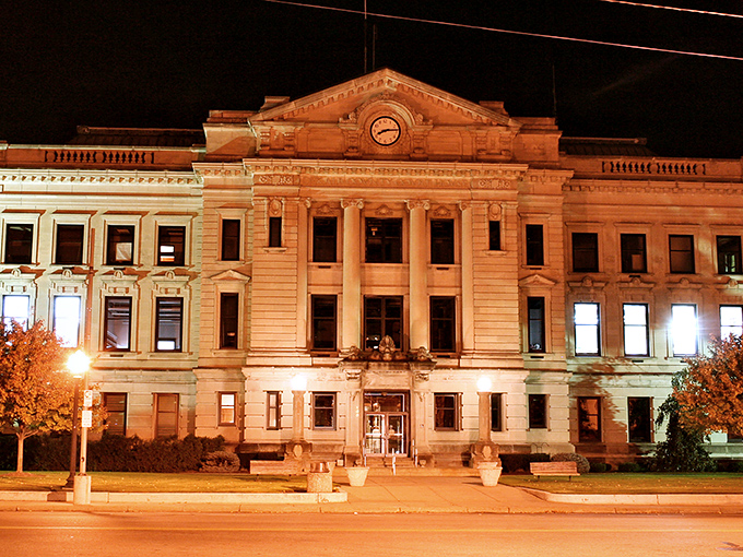 Marvel at the historic architecture of this grand building as its golden glow warms your heart on a quiet evening.