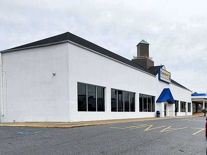 The clean white exterior of Goodwill Wilmington gleams in the sunlight, promising air-conditioned treasure hunting inside.