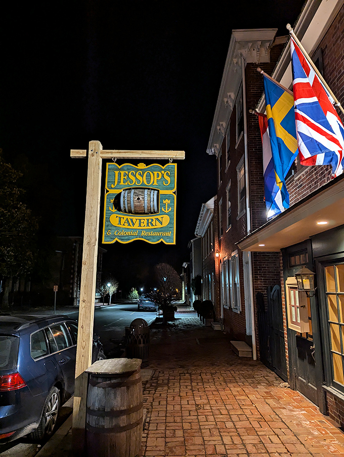 Nighttime at Jessop's Tavern feels like time travel with better food. Those flags aren't just decorative – they're waving you inside!