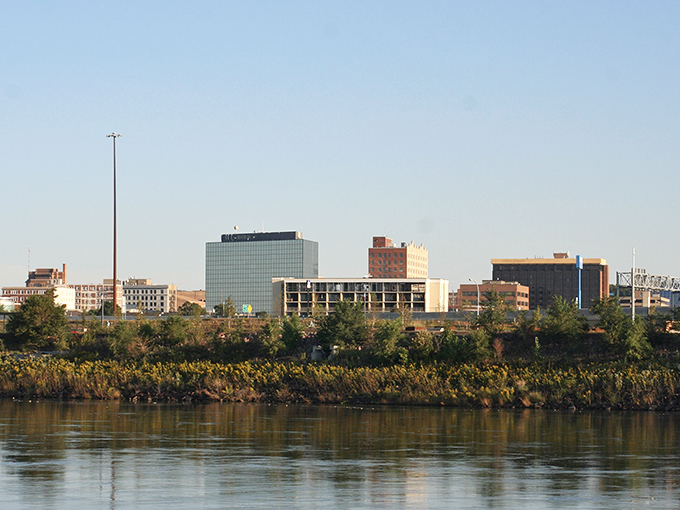 The Sioux City skyline rises above the Missouri River, showcasing its modest downtown with a mix of modern and historic buildings.