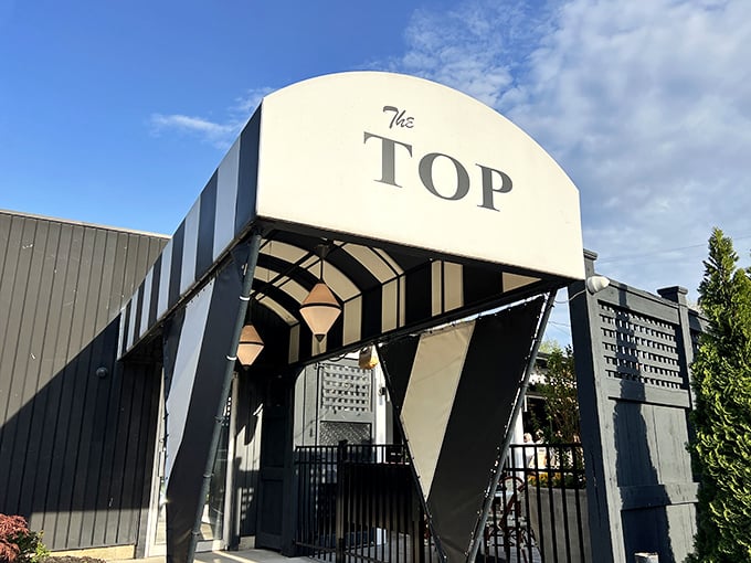 The Top's distinctive entrance stands ready to transport you to a world where steaks sizzle and martinis chill to perfection.
