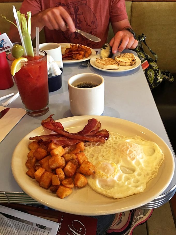 The holy trinity of breakfast: perfectly sunny eggs, golden home fries, and bacon that's achieved that mythical balance between crisp and chewy.