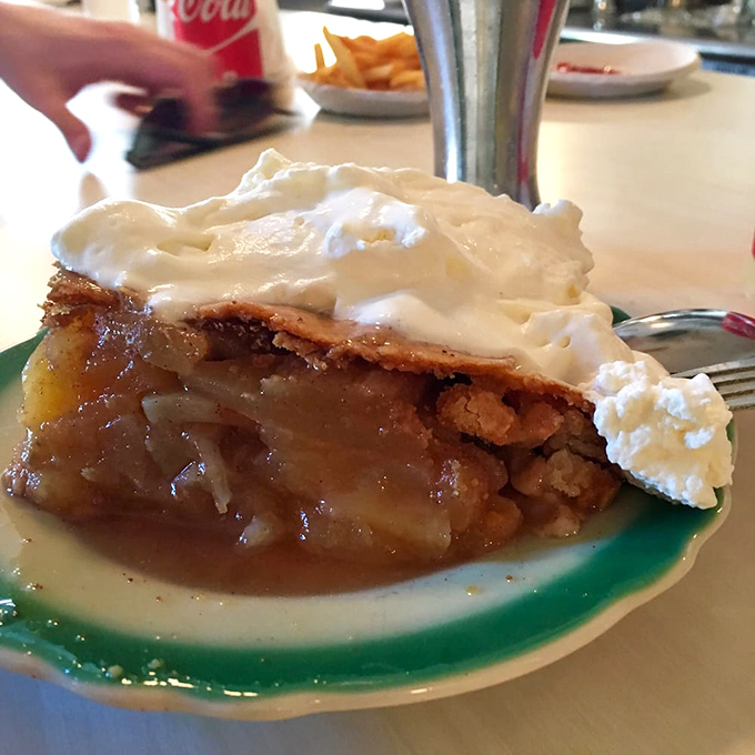 The apple pie arrives with a cloud of whipped cream that doesn't so much sit on top as float above it like a delicious cumulus formation.