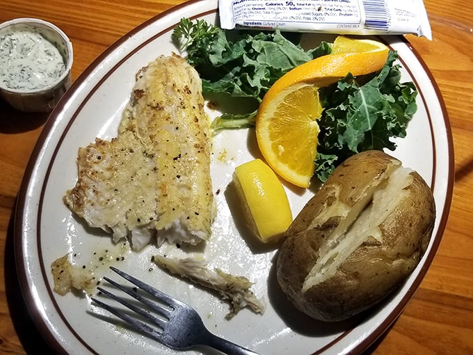 The humble baked potato—nature's perfect vessel for butter—sits alongside perfectly grilled fish like old friends catching up.