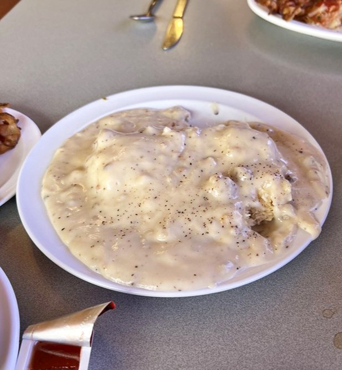 This isn't just gravy&mdash;it's a peppery, sausage-studded blanket lovingly tucked around a biscuit that clearly had a proper upbringing in a real kitchen.