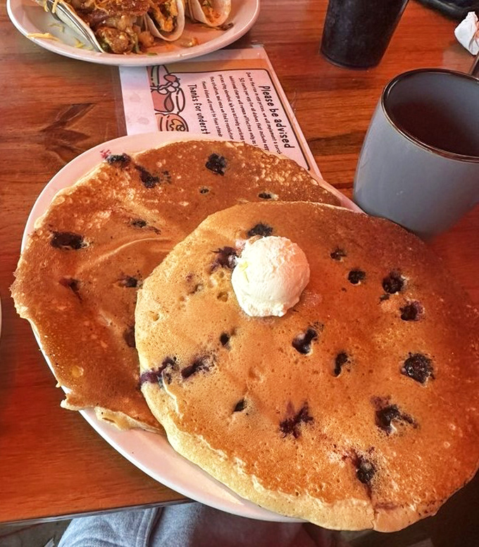 Blueberry pancakes so generous with berries they could qualify as a fruit serving. The coffee cup standing guard knows its supporting role.