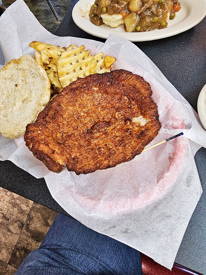 The breaded tenderloin &ndash; an Indiana classic that hangs over the plate like a crispy golden frisbee. Sandwich-to-bun ratio: gloriously absurd.