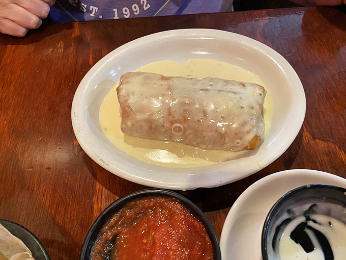 The burrito that launched a thousand road trips. Bathed in creamy queso and accompanied by salsa that means business.