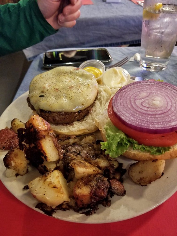 The burger arrives with potatoes that look like they've been kissed by fire, then blessed by seasoning gods with a heavy hand.