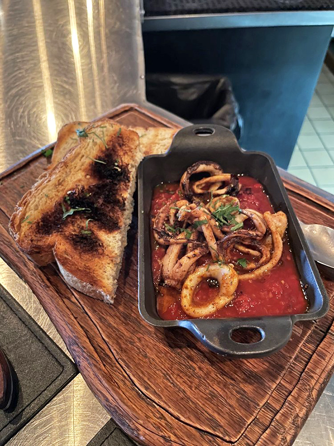Calamari swimming in vibrant tomato sauce with charred bread for dipping&mdash;proof that seafood this fresh doesn't need a fancy introduction.